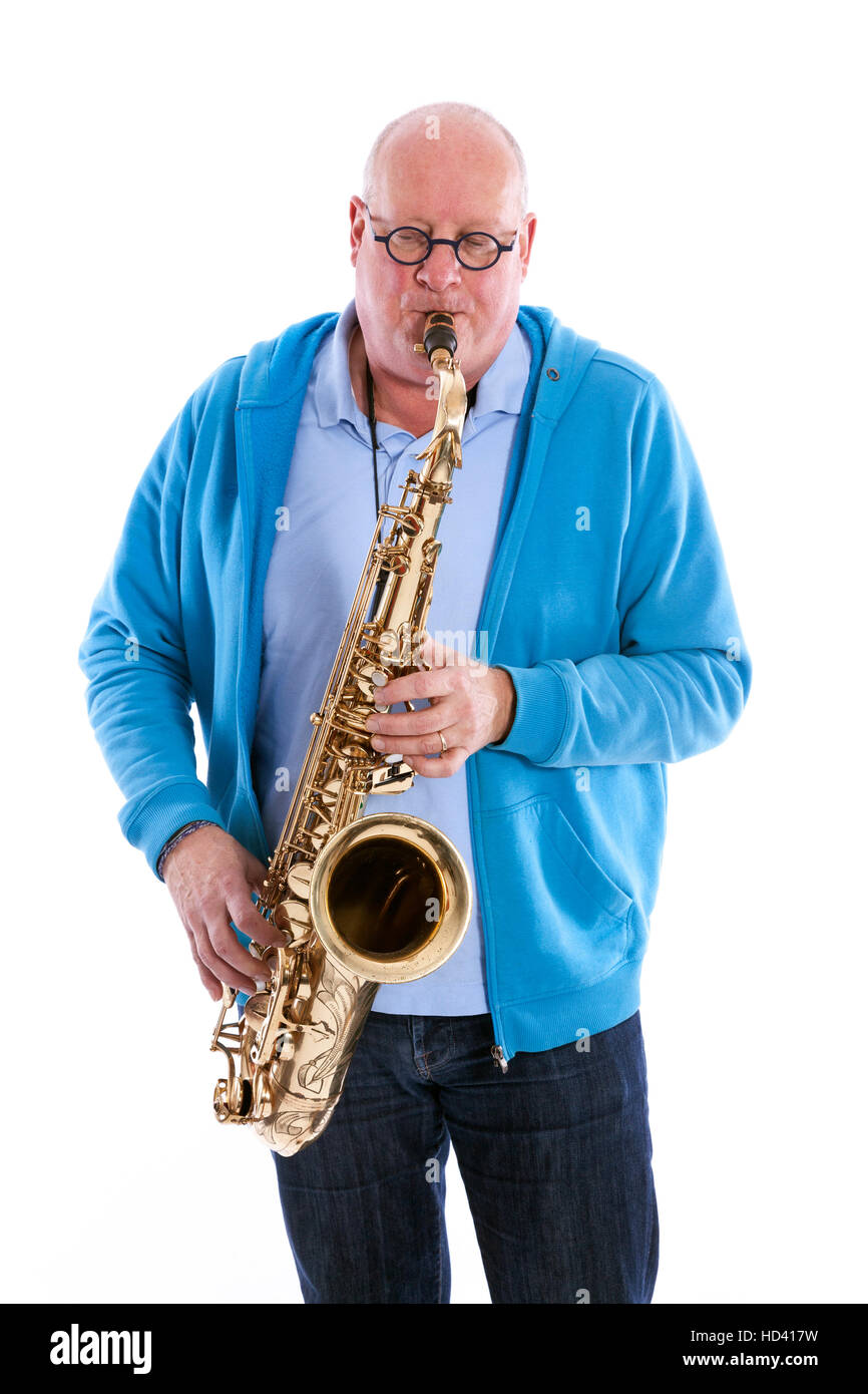 middle aged man in blue plays the tenor saxophone against white studio ...