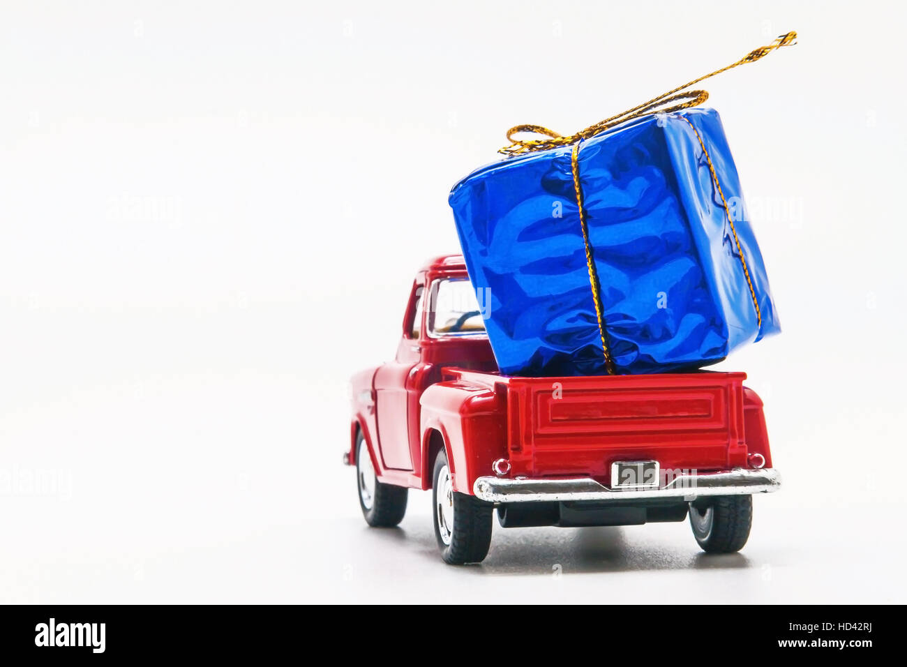 red retro car pickup with a blue gift box isolated Stock Photo - Alamy