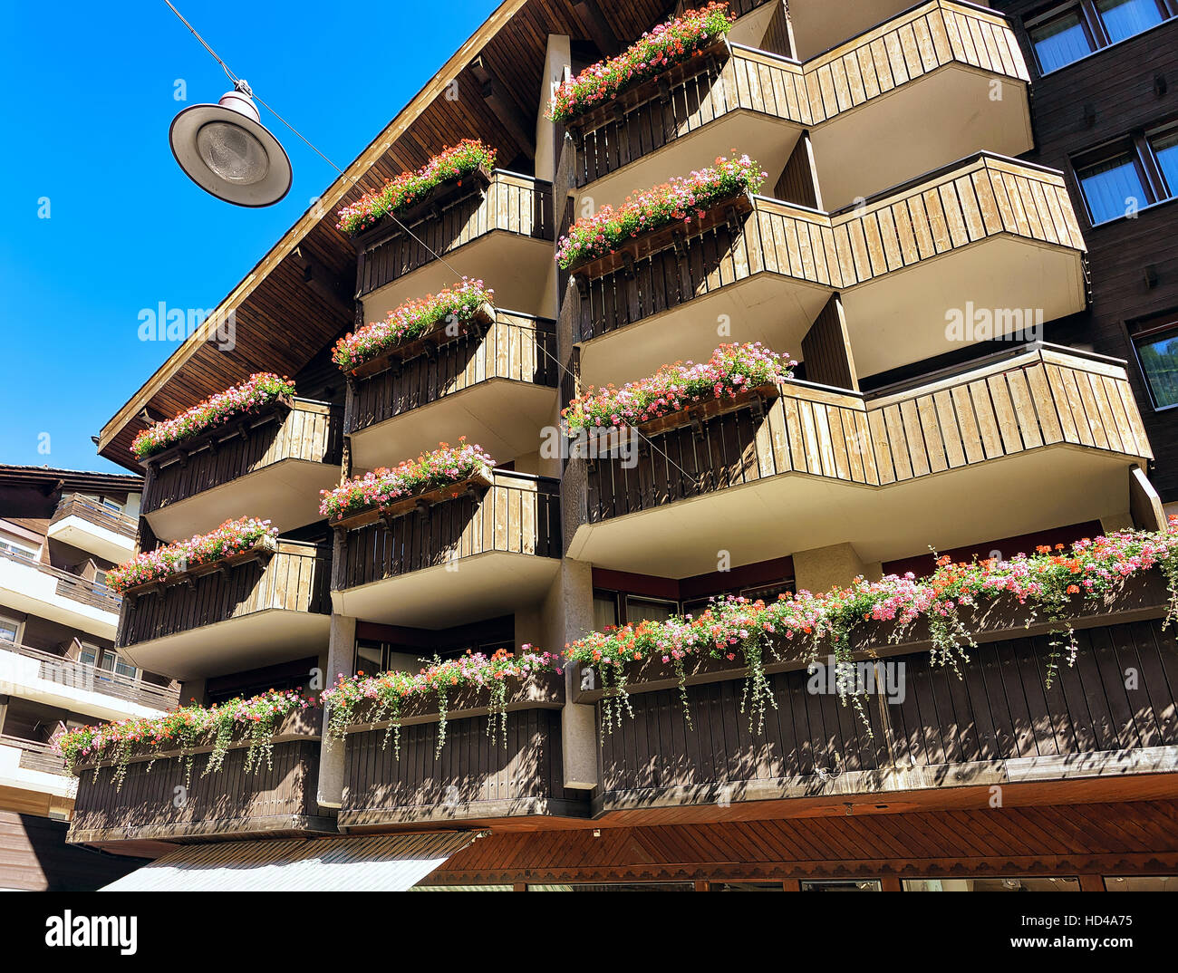Traditional Swiss chalets with flowers on balconies in resort city ...