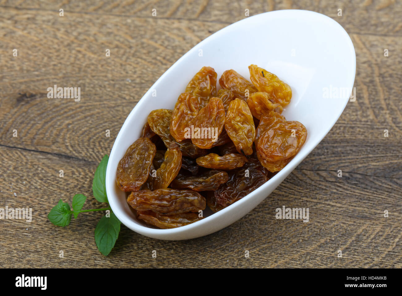 Sweet raisins in the bowl with mint leaves Stock Photo - Alamy
