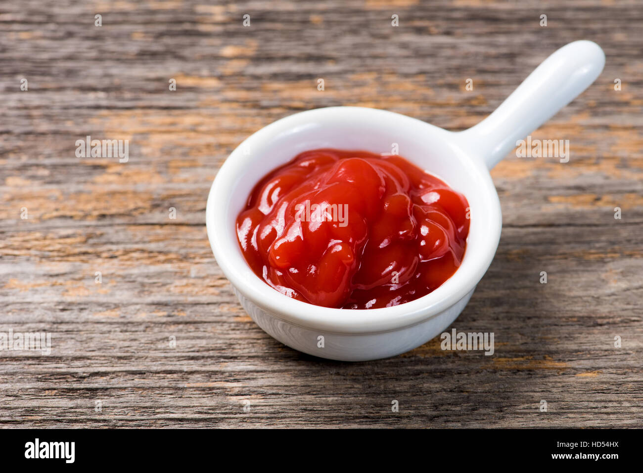 Container of ketchup on the table in natural light Stock Photo - Alamy