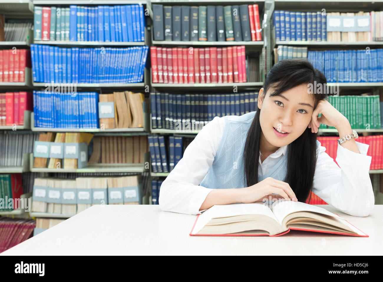 Asian student reading book in library at university Stock Photo - Alamy