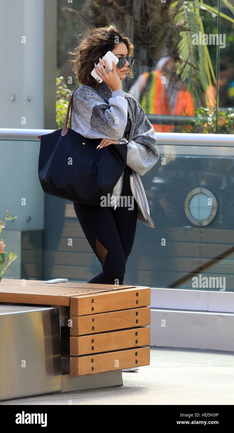 Vanessa Hudgens hides her face with her cell phones as she arrives at ...