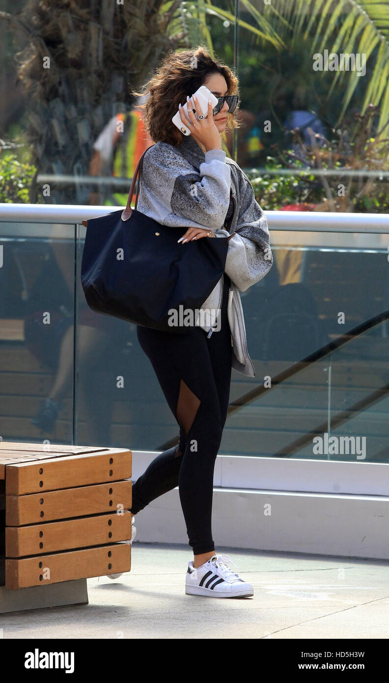 Vanessa Hudgens hides her face with her cell phones as she arrives at ...