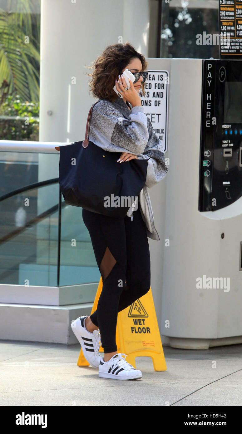 Vanessa Hudgens hides her face with her cell phones as she arrives at ...