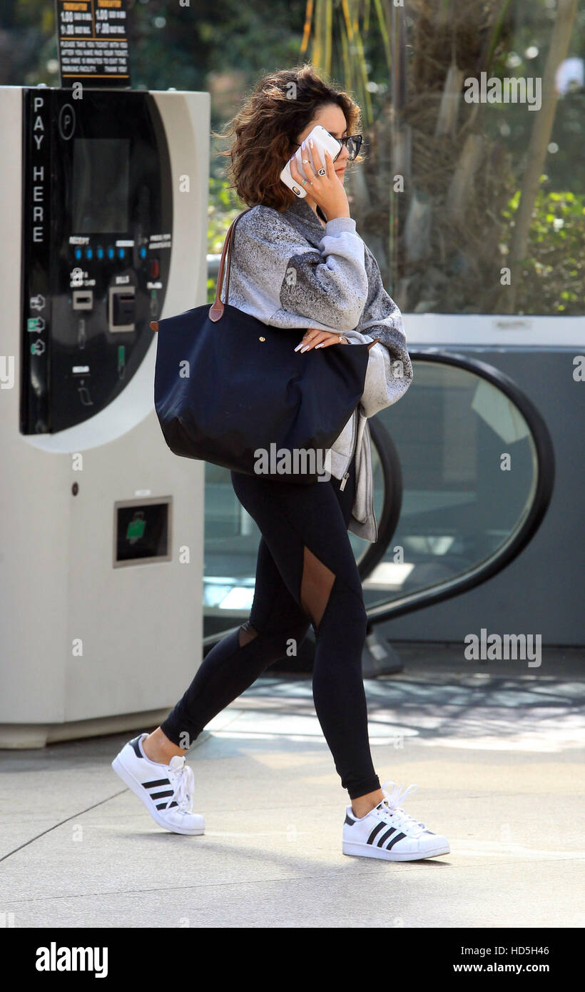 Vanessa Hudgens hides her face with her cell phones as she arrives at ...