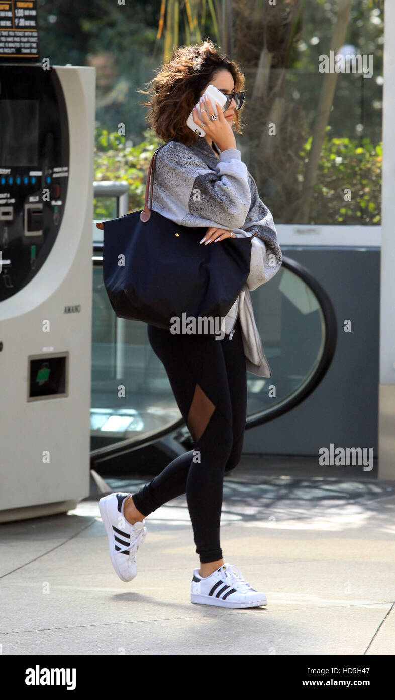 Vanessa Hudgens hides her face with her cell phones as she arrives at ...