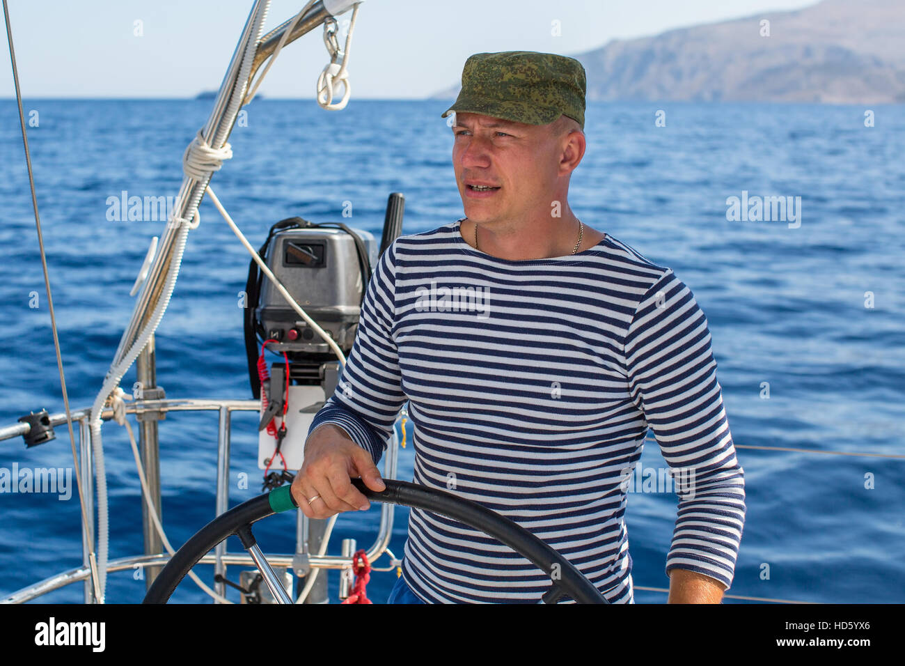 Man at the helm on the sailing boat. Ship controls during sea yacht ...