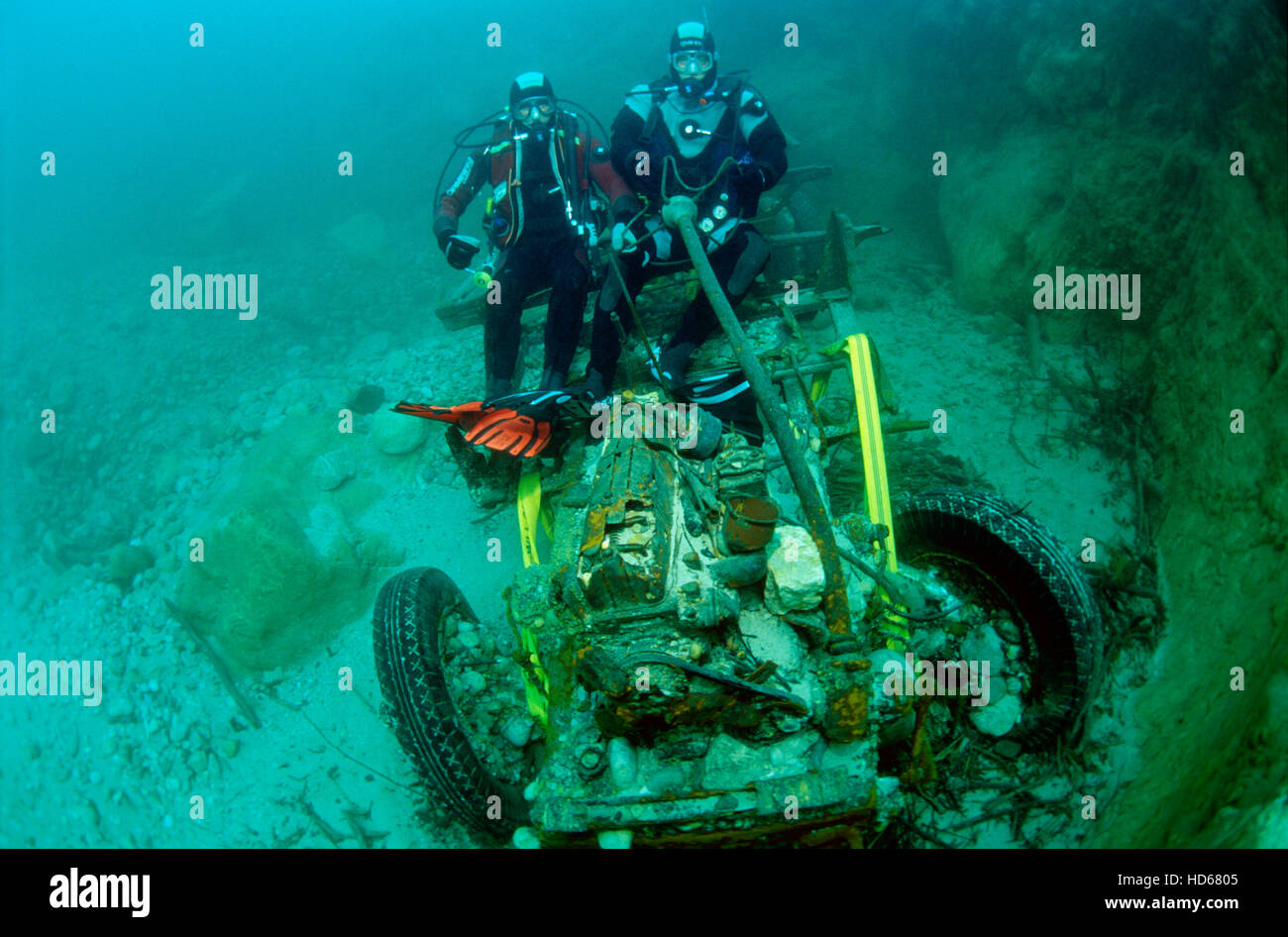 Two scuba divers on a sunken truck from the 2nd World War in the river ...