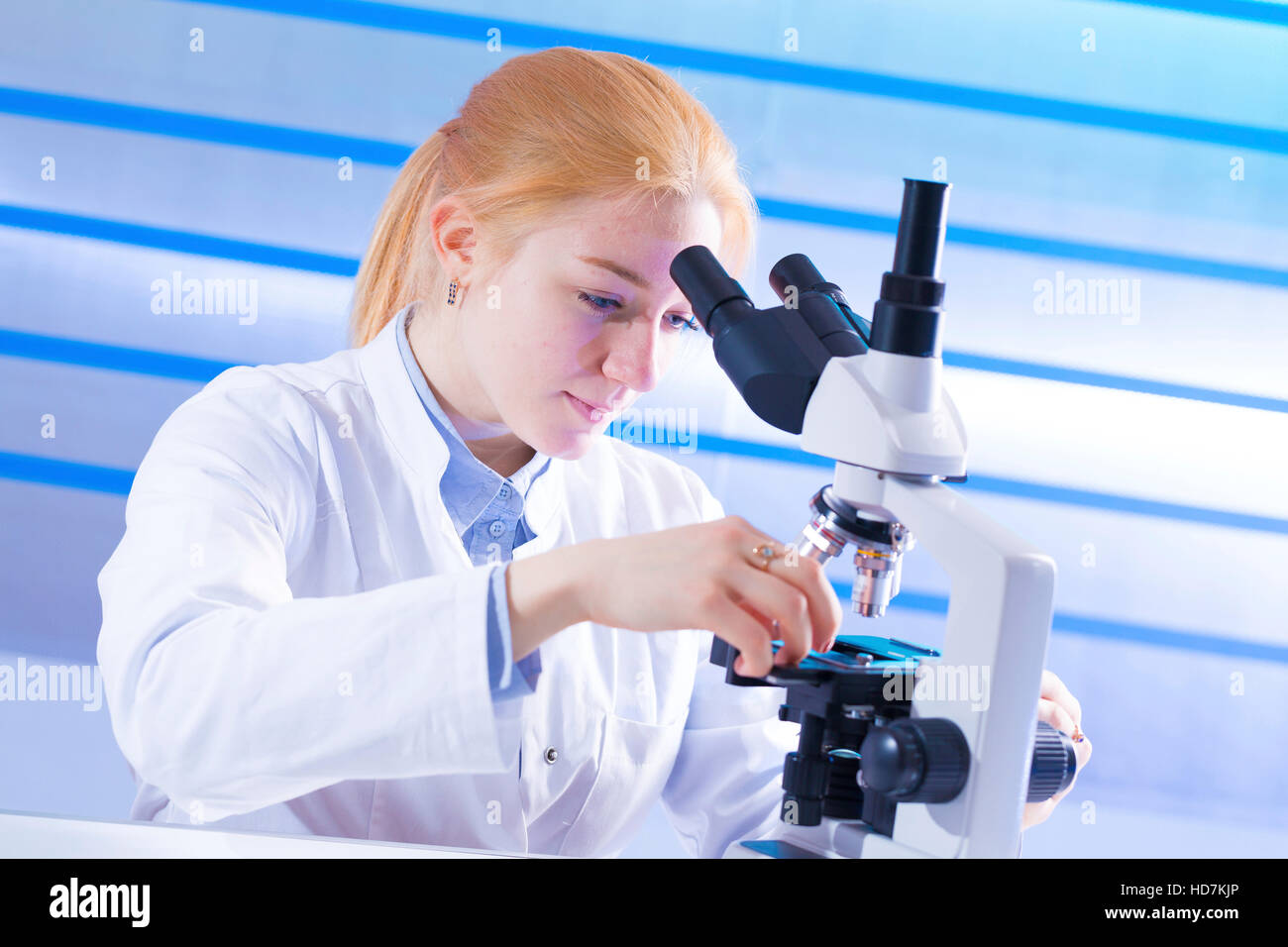 MODEL RELEASED. Young woman using microscope Stock Photo - Alamy