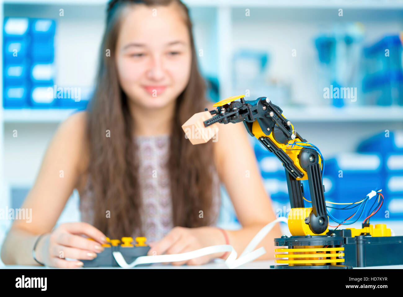 MODEL RELEASED. Girl controlling robot in laboratory Stock Photo - Alamy