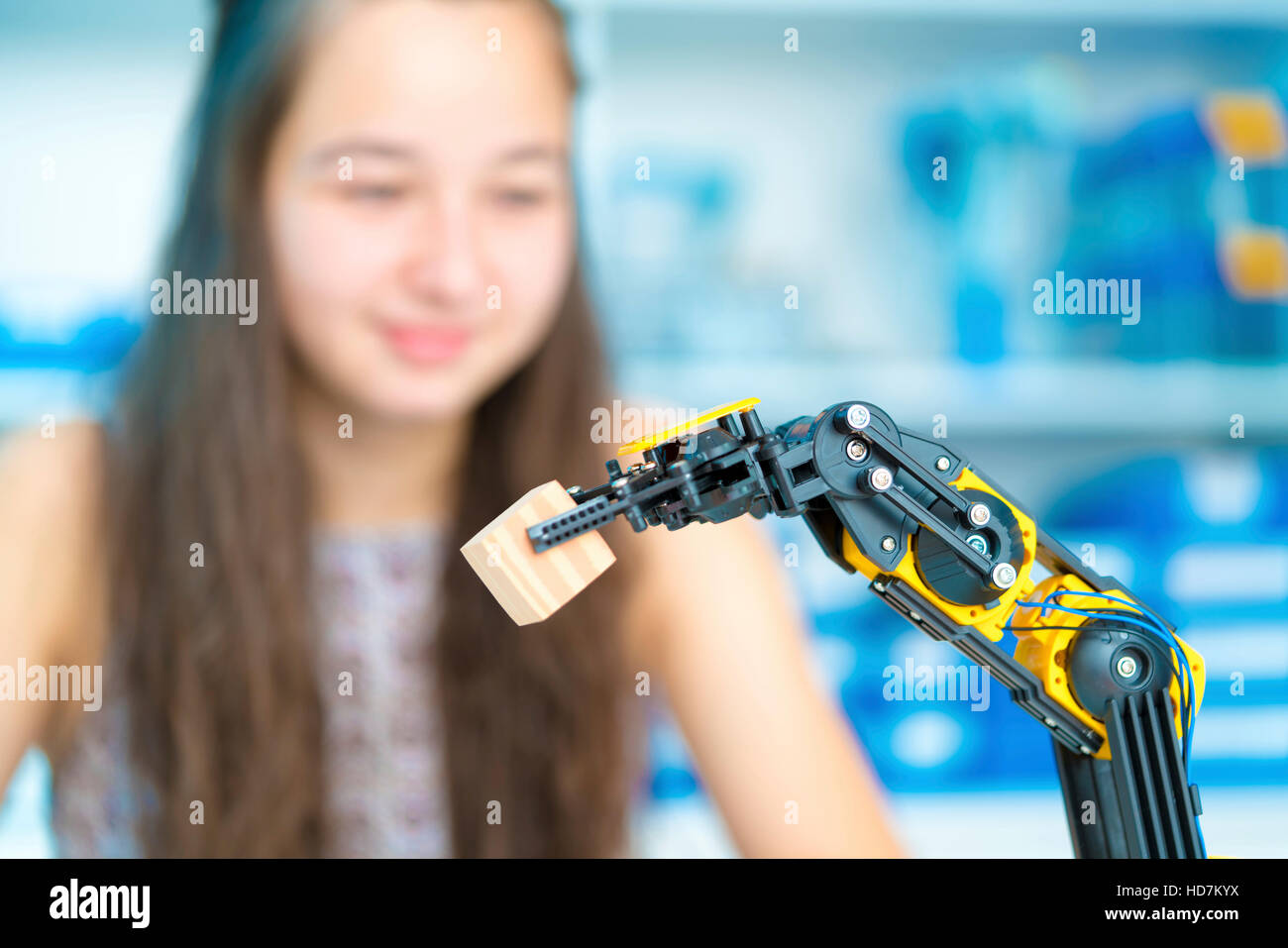 MODEL RELEASED. Girl controlling robot in laboratory Stock Photo - Alamy
