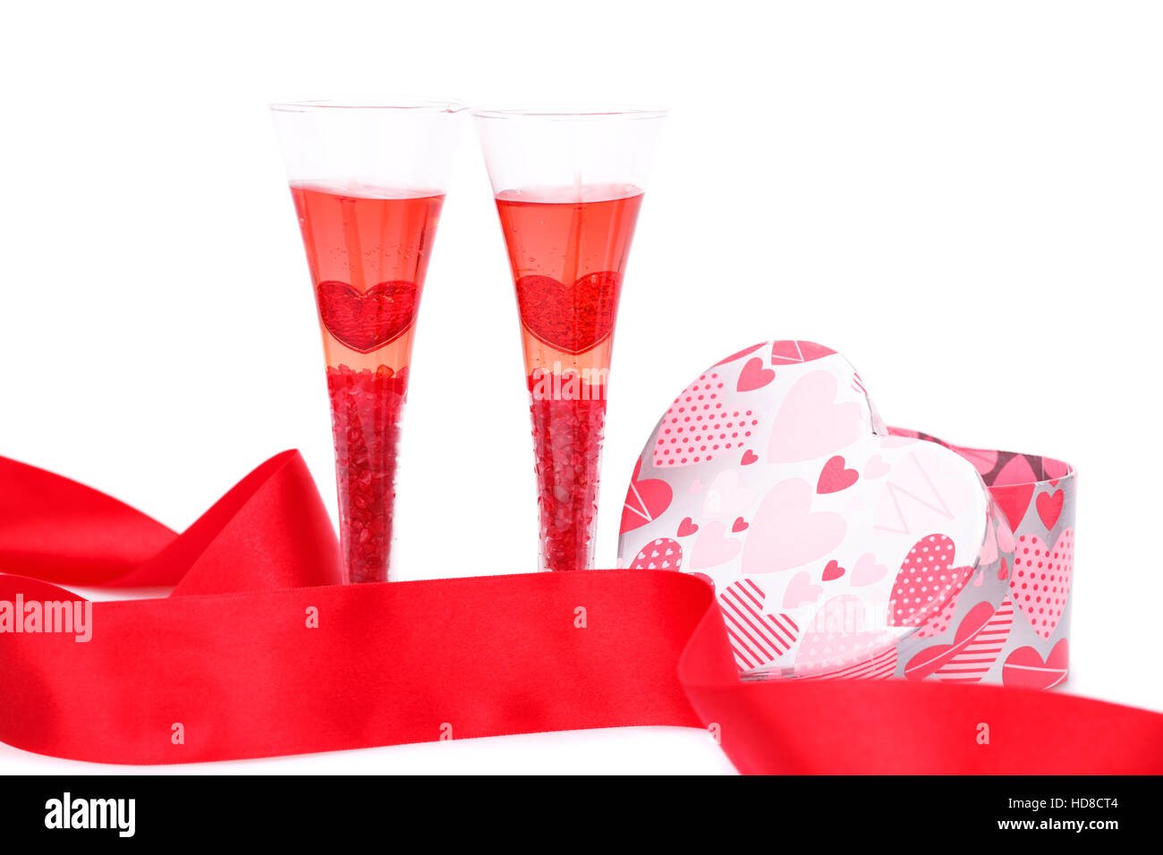 Two glasses with red candle, gift box and red ribbon isolated on white ...