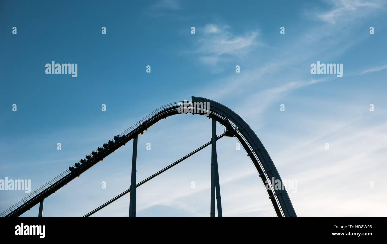 A roller coaster going up the tracks against a blue sky Stock Photo - Alamy