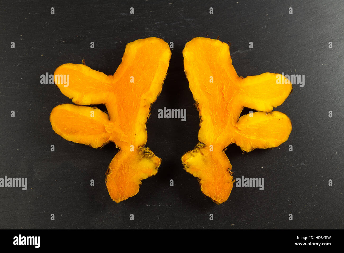 Piece sliced and two halves shown of turmeric or Curcuma longa root on ... Piece sliced and two halves shown of turmeric or Curcuma longa root on ...