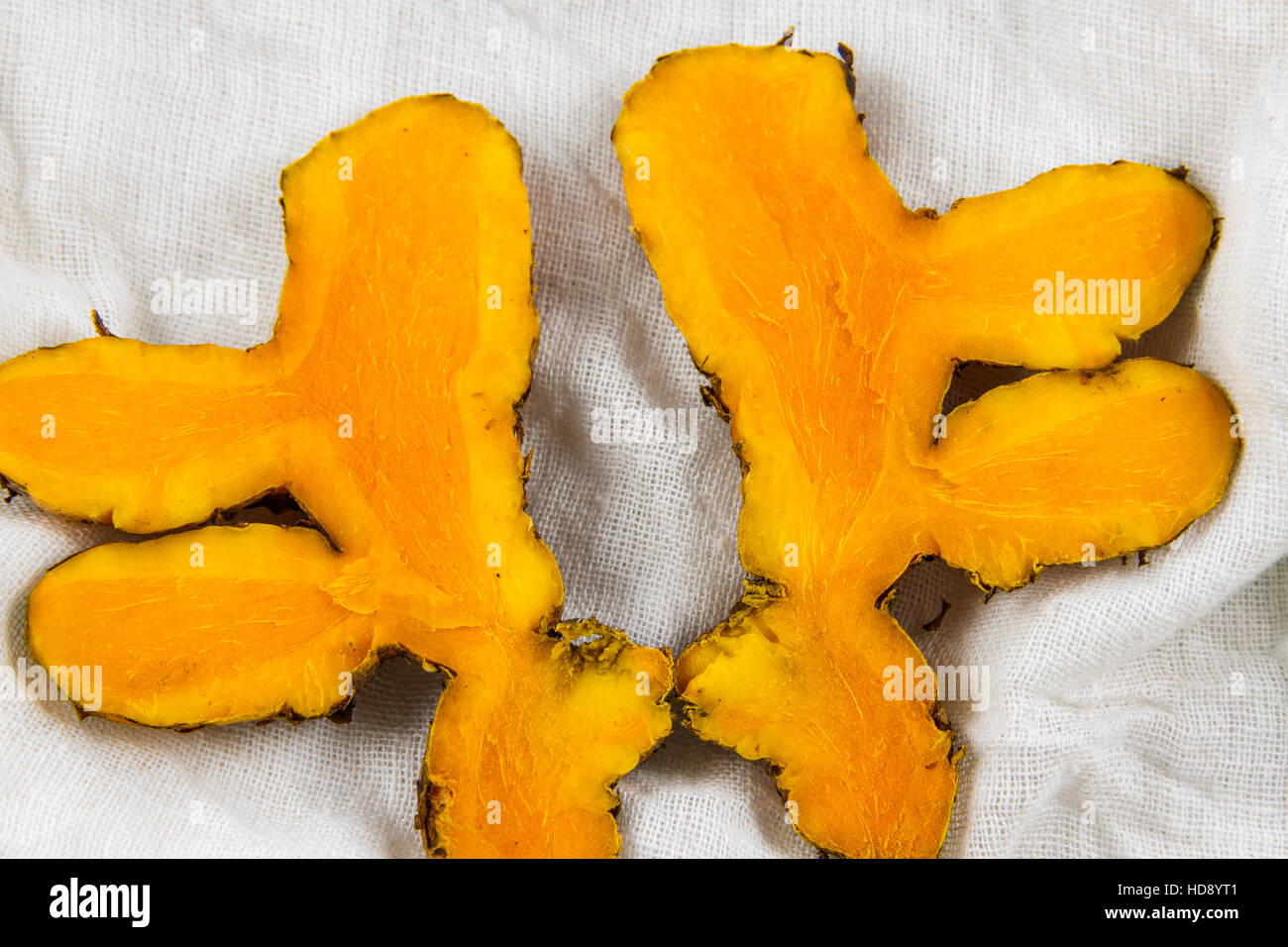 Piece sliced and two halves shown of turmeric or Curcuma longa root on ... Piece sliced and two halves shown of turmeric or Curcuma longa root on ...