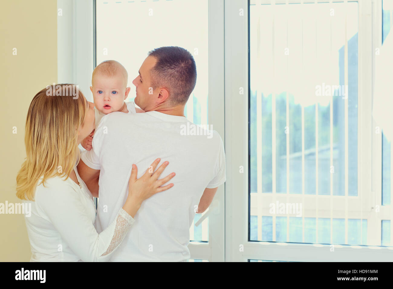 Happy family at the window. Mother, father with a baby inside Stock ...