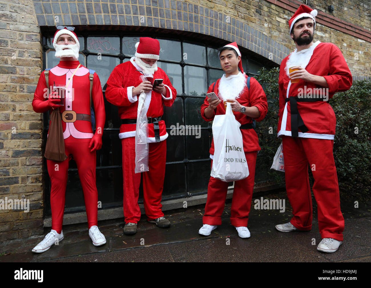 Four revellers dressed in Santa suits in Camden in north London, before ...