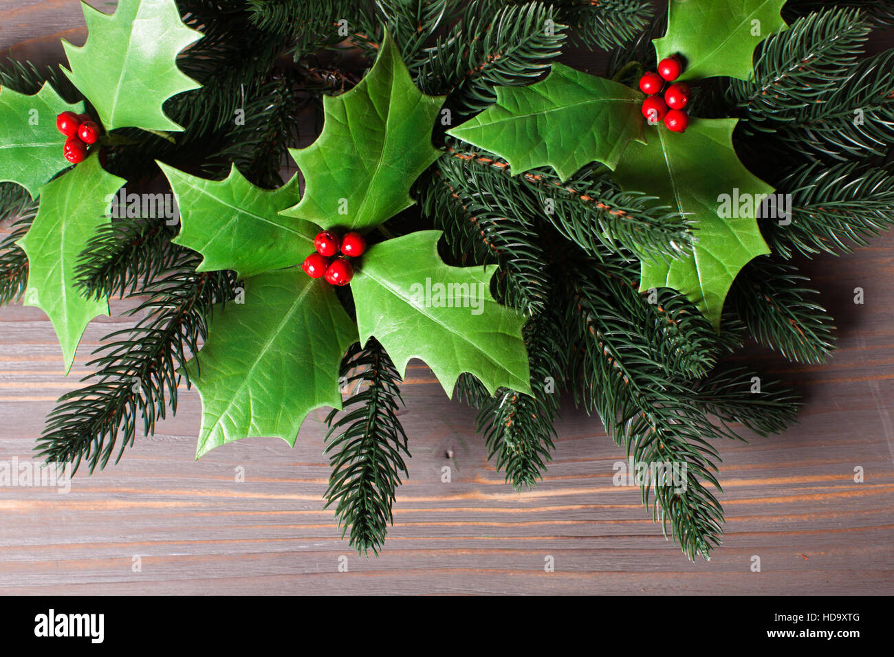 Holly and fir twigs on wood wall Stock Photo - Alamy