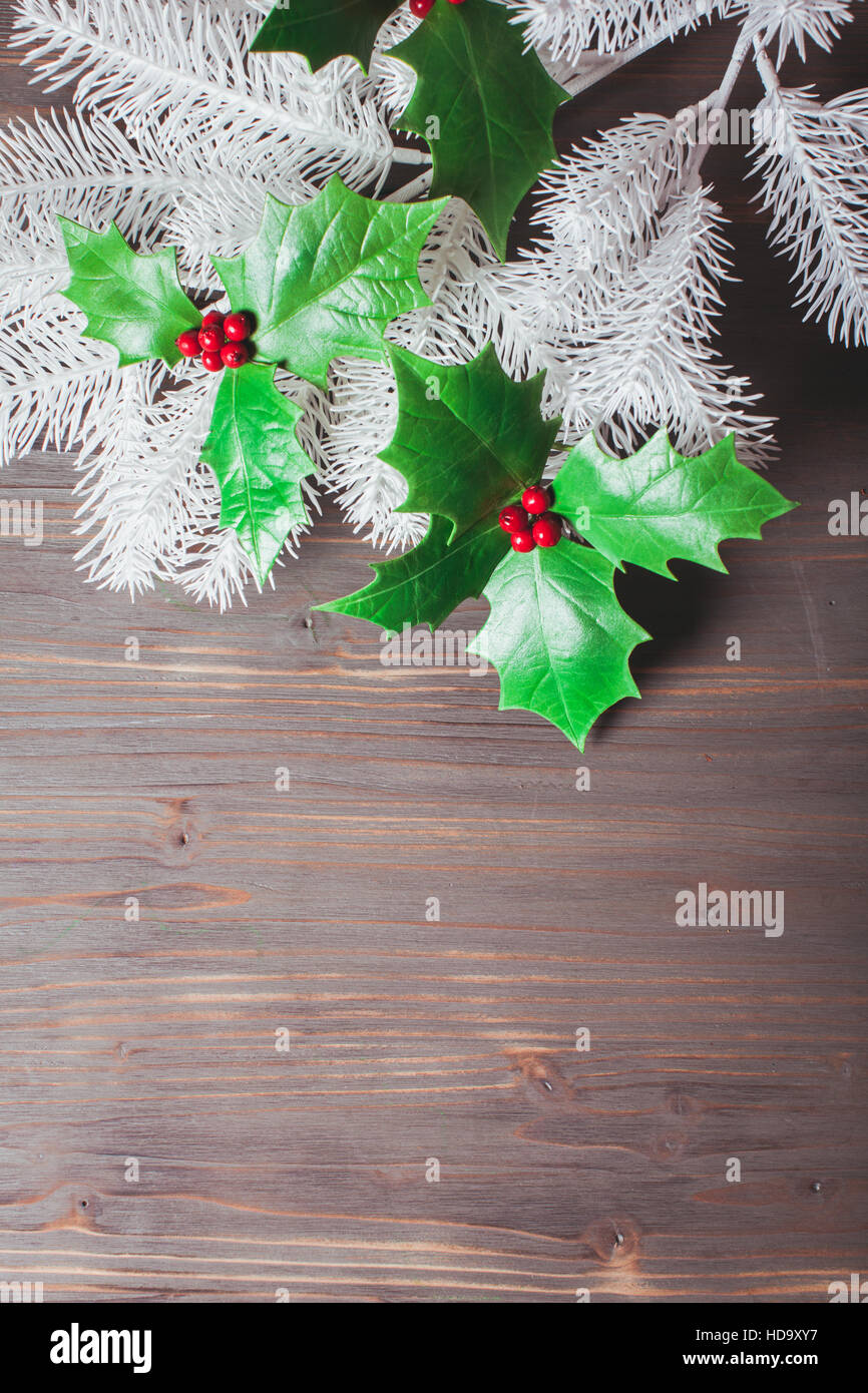 Holly and fir twigs on wood wall Stock Photo - Alamy
