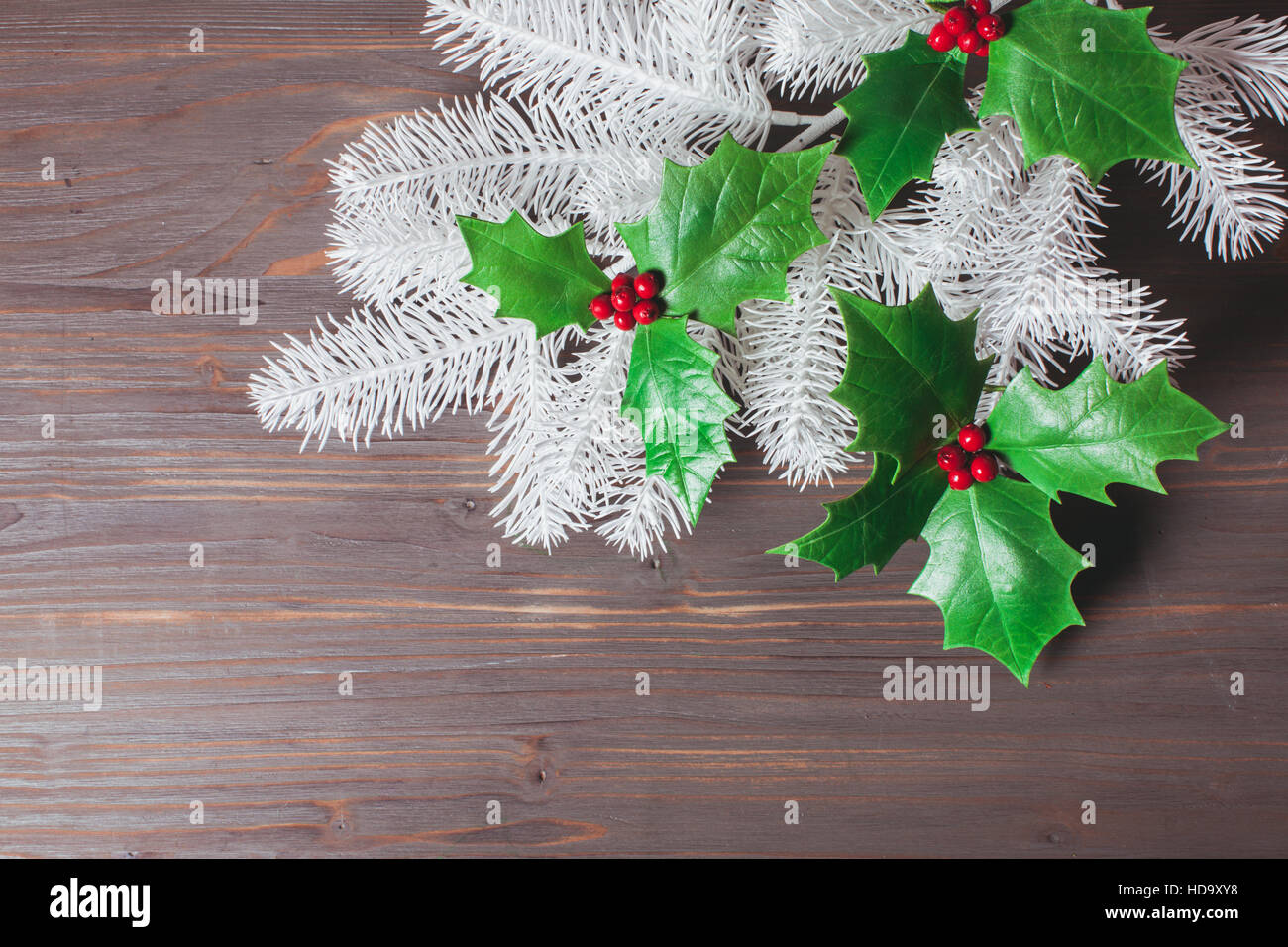 Holly and fir twigs on wood wall Stock Photo - Alamy
