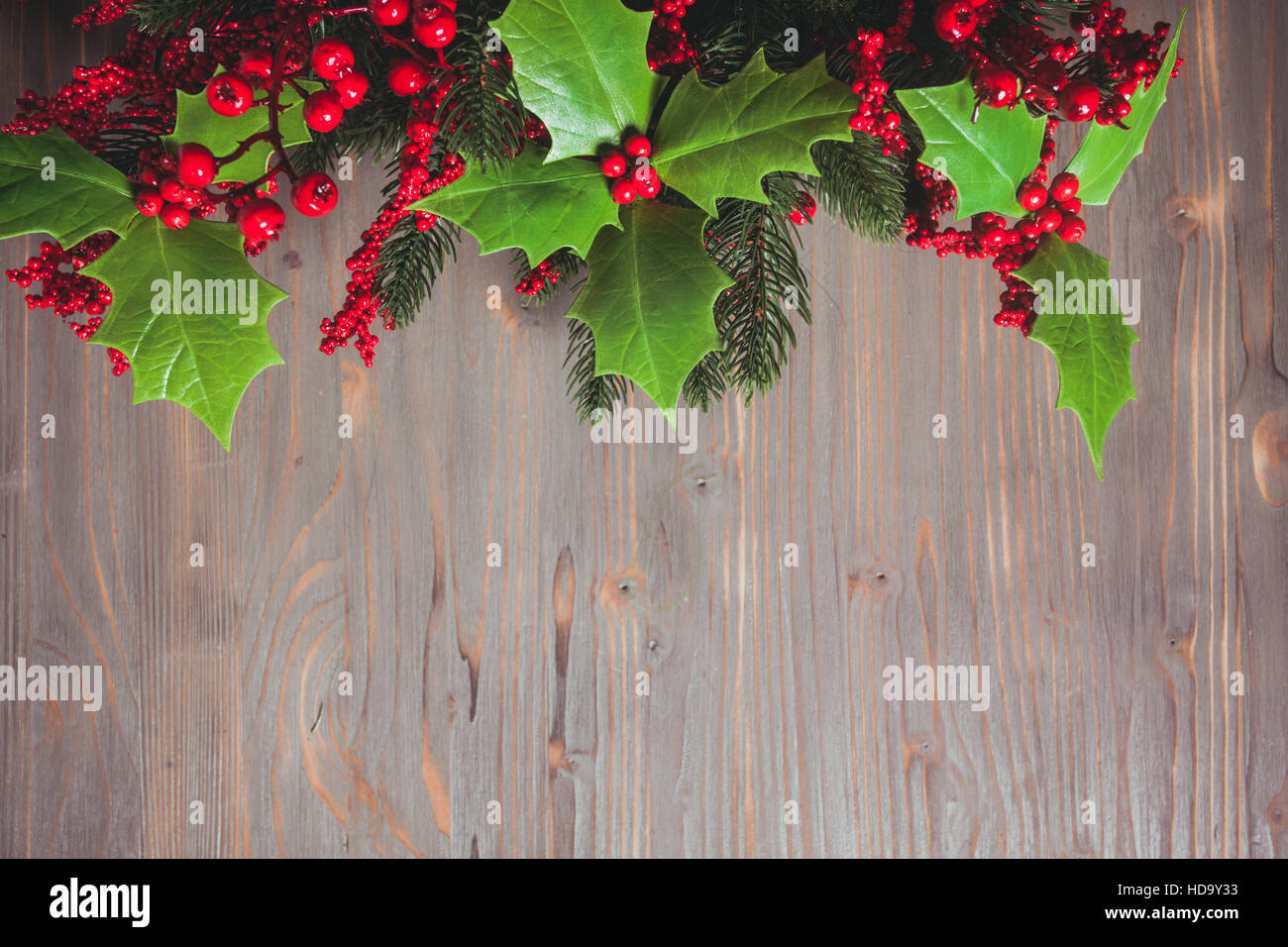 Holly and fir twigs on wood wall Stock Photo - Alamy