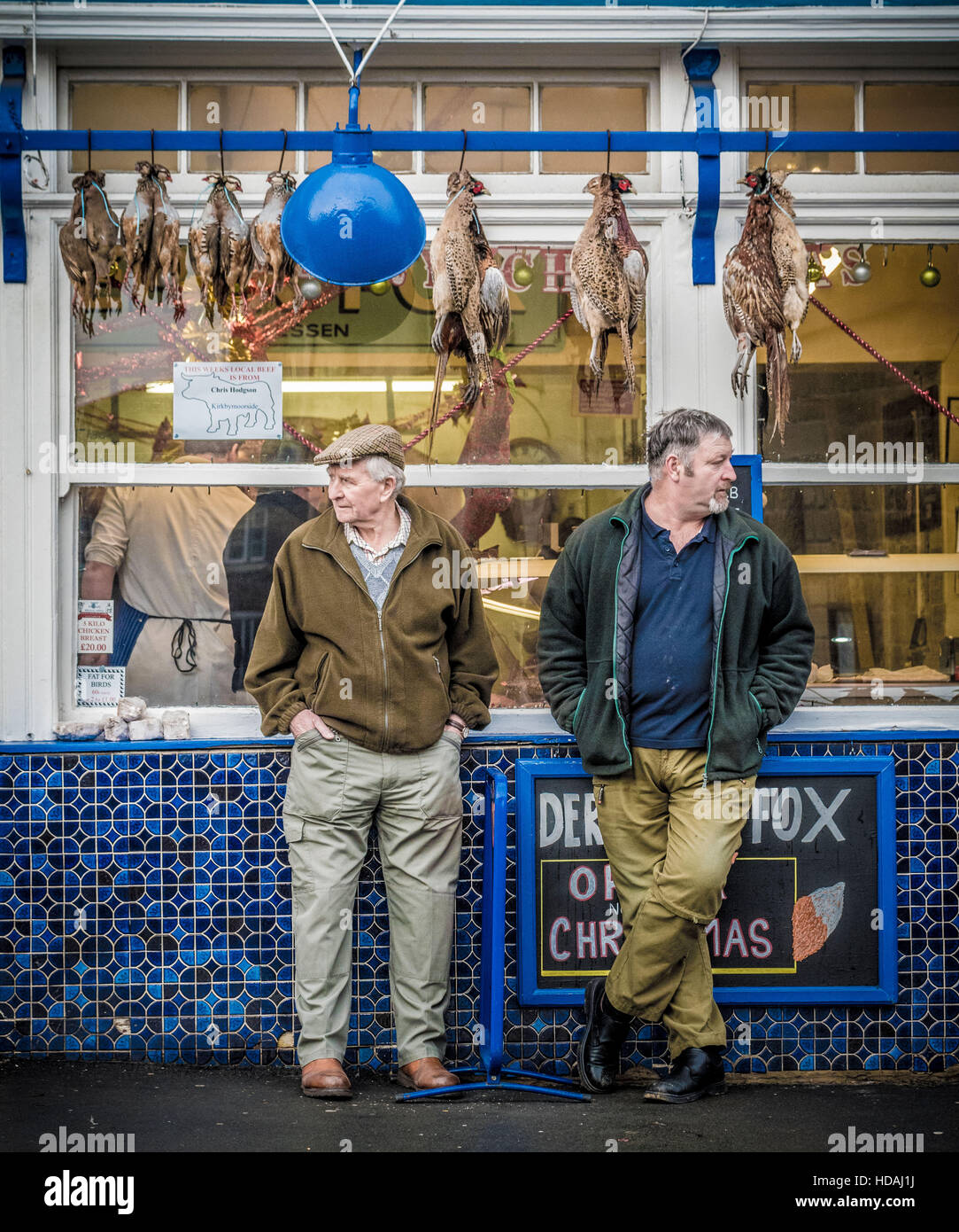 2 mature men standing outside a butchers shop hi-res stock photography ...