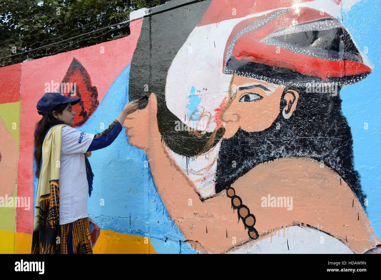 Lahore. 11th Dec, 2016. A Pakistani student paints on a wall along a ...