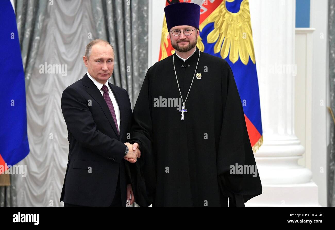 Russian President Vladimir Putin presents Orthodox arch-priest Aleksandr Tkachenko, director of ...