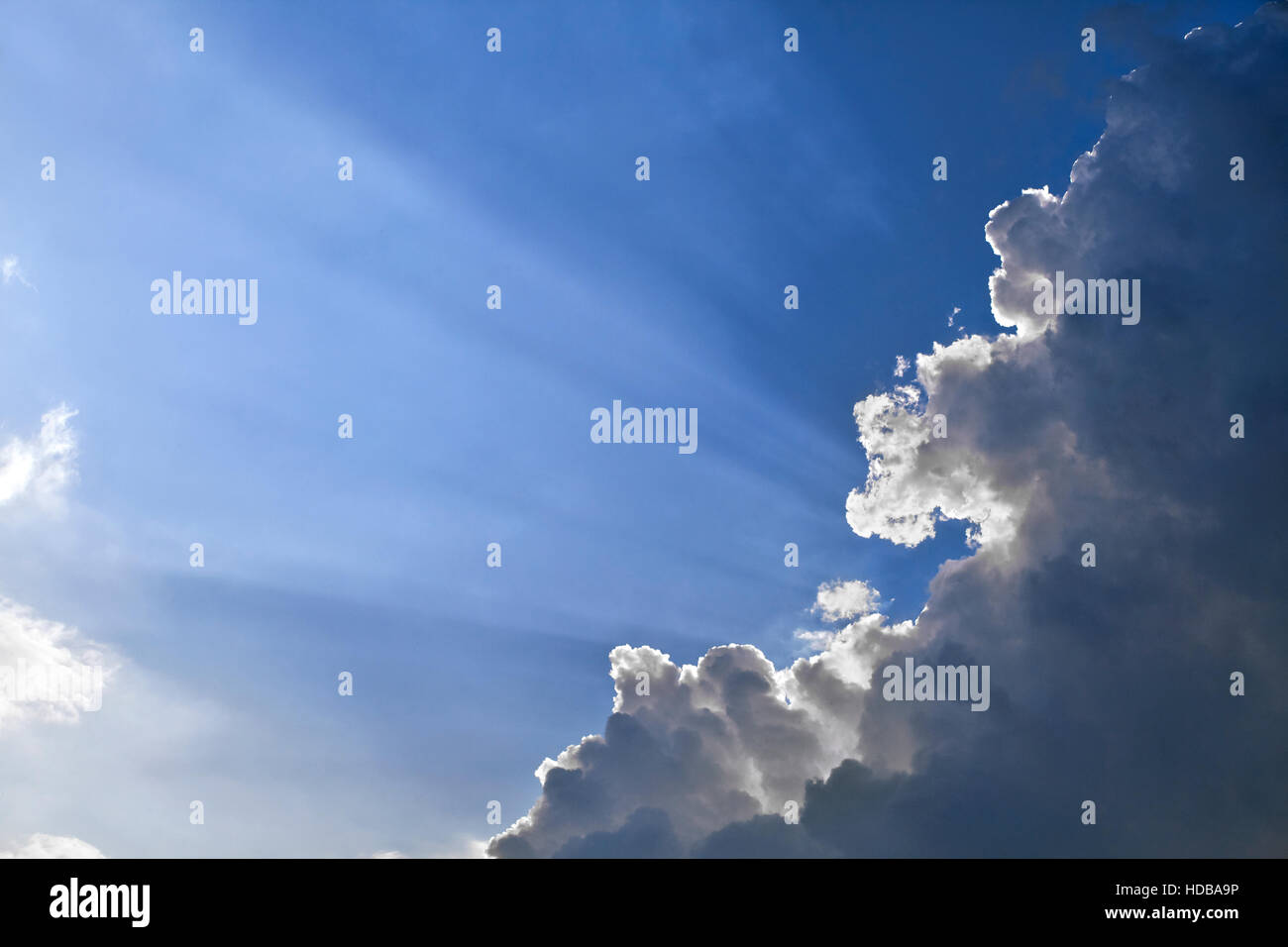 Sun rays through a cloud on a summer day Stock Photo - Alamy