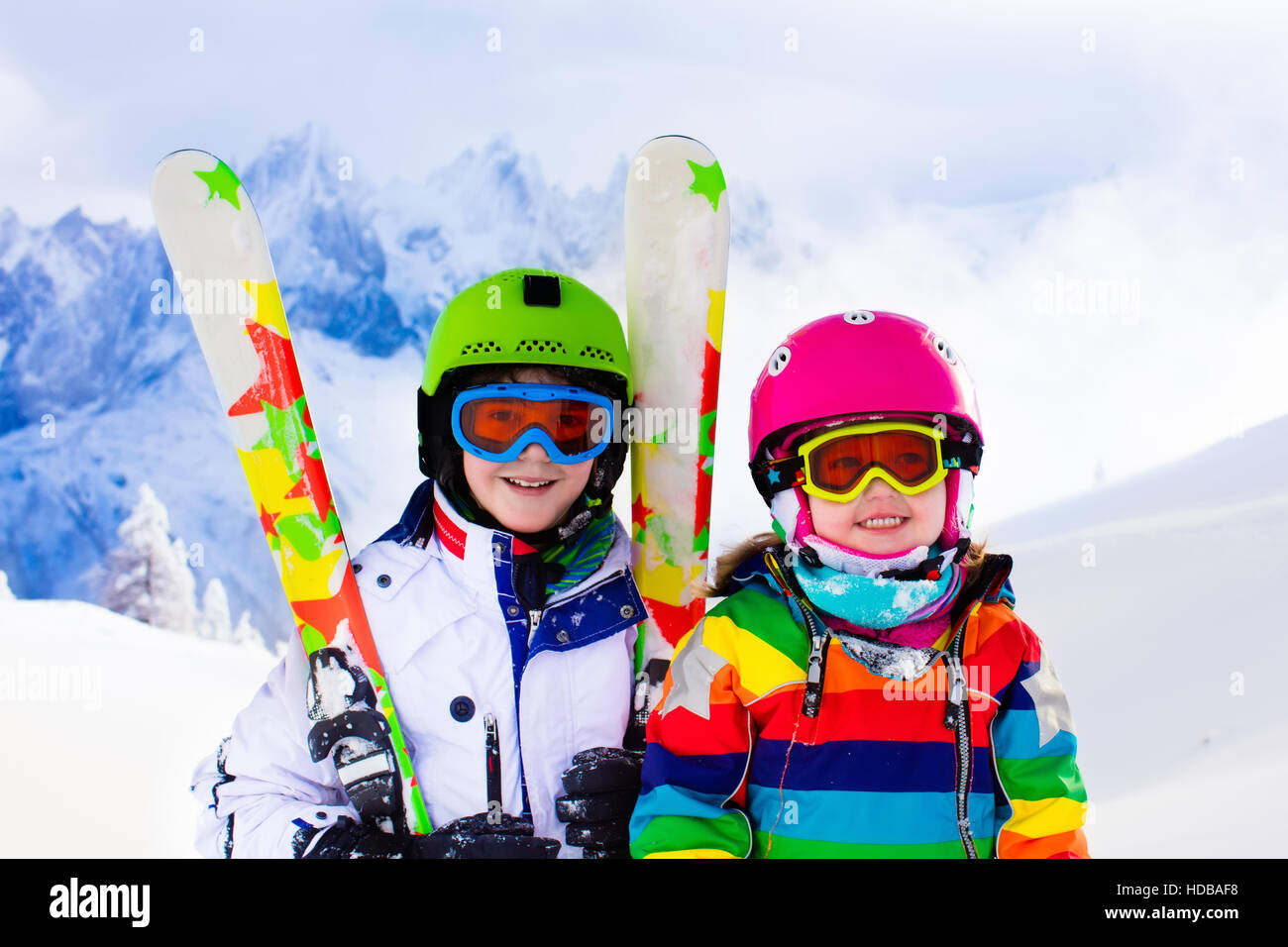 Kids skiing in mountains. Active children with safety helmet, goggles ...