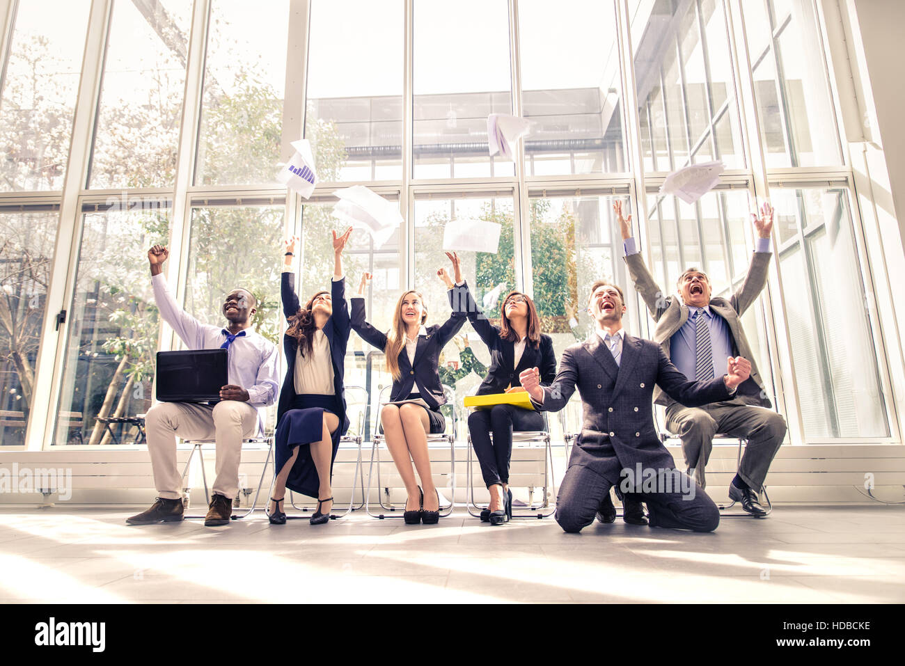 Business team exulting - Happy cheerful businessmen rising arms and ...
