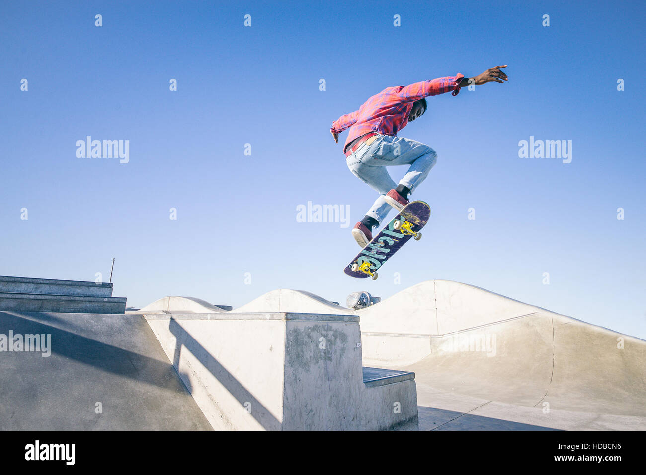 Skateboarder doing a trick in a skate park Stock Photo - Alamy