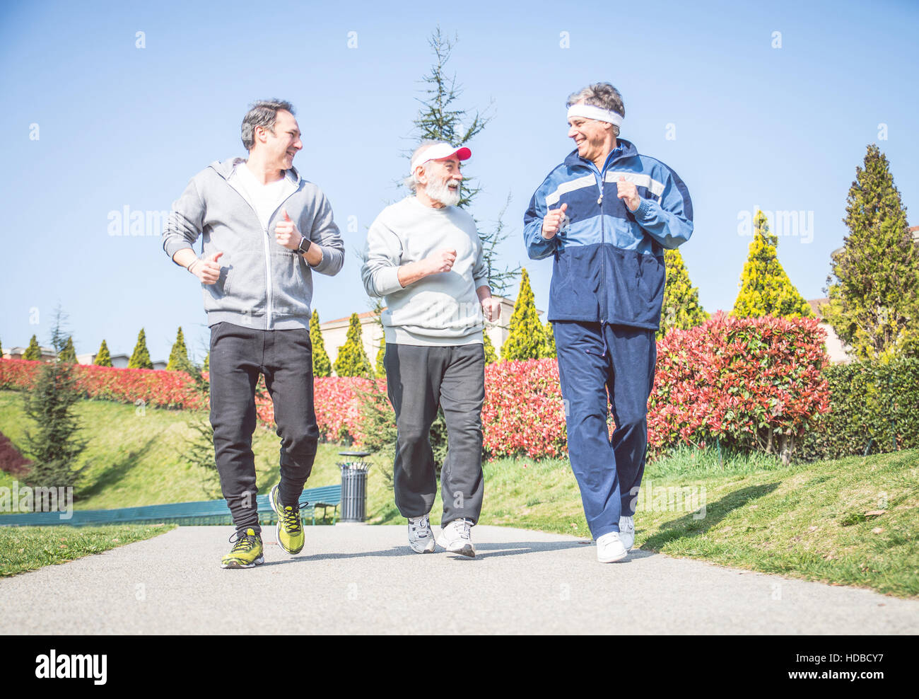 Three senior men running in a park - Mature athletic friends jogging ...