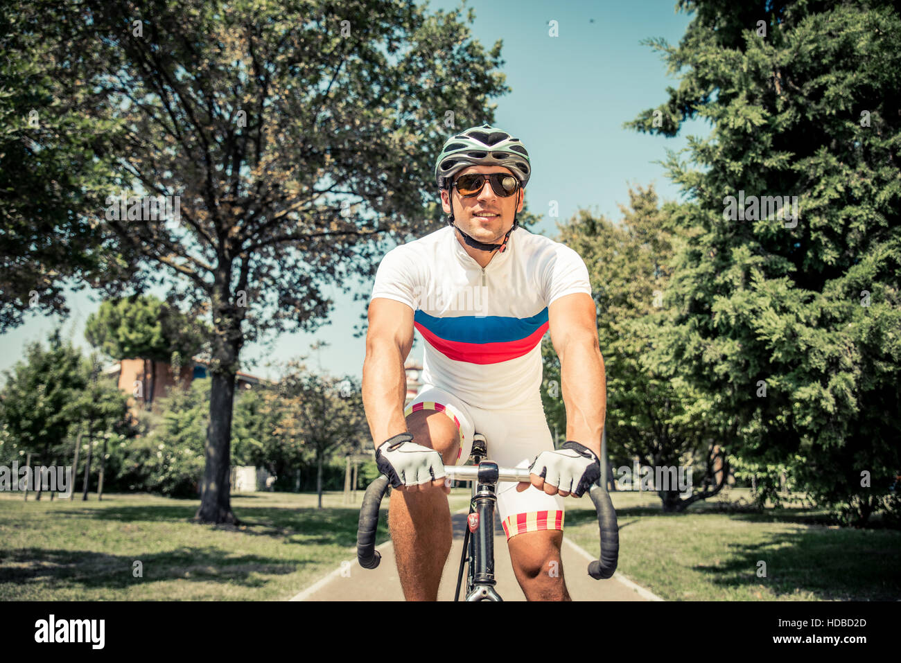 Athlete cycling in a park - Professional cyclist training outdoors ...