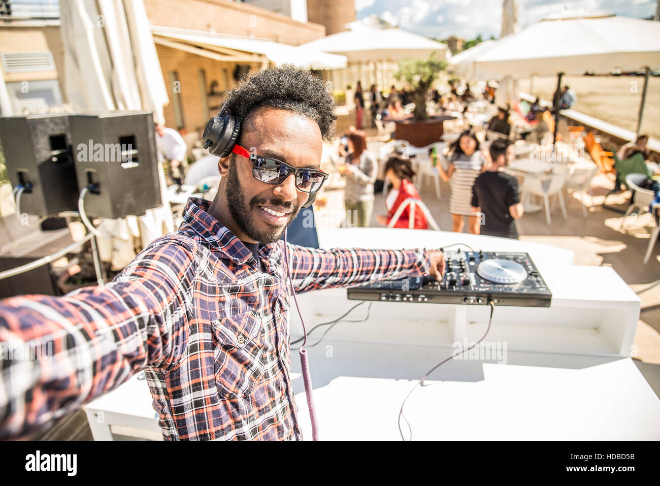 Dj taking a selfie while mixing music on a deejay set in a club, people ...