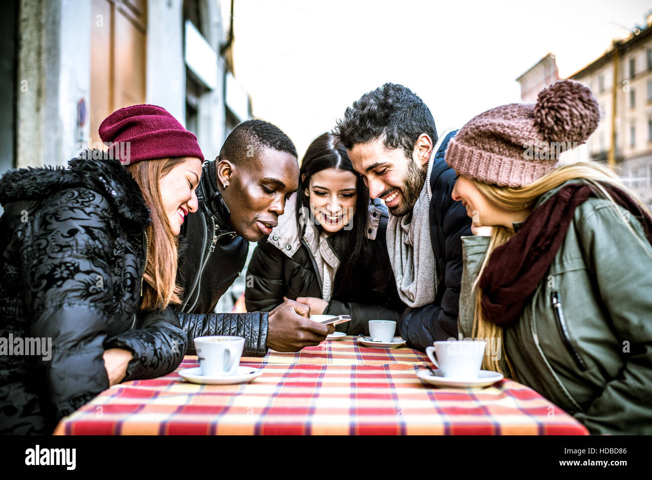 Group of multi-ethnic friends sitting in a bar and talking - Young ...