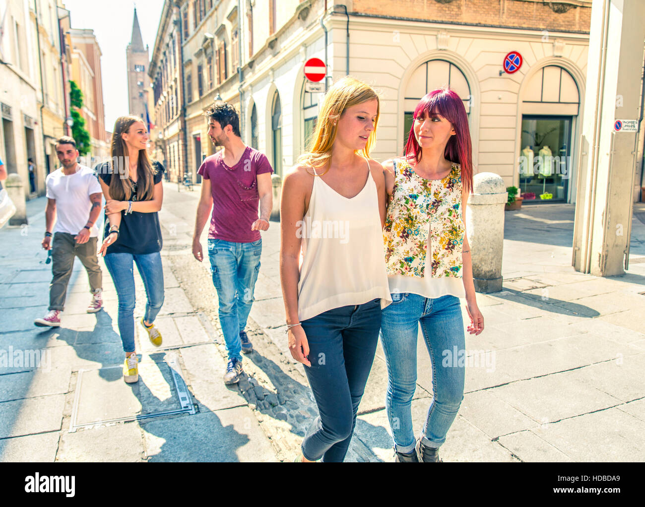Group of friends walking outdoors while speaking and gesturing ...