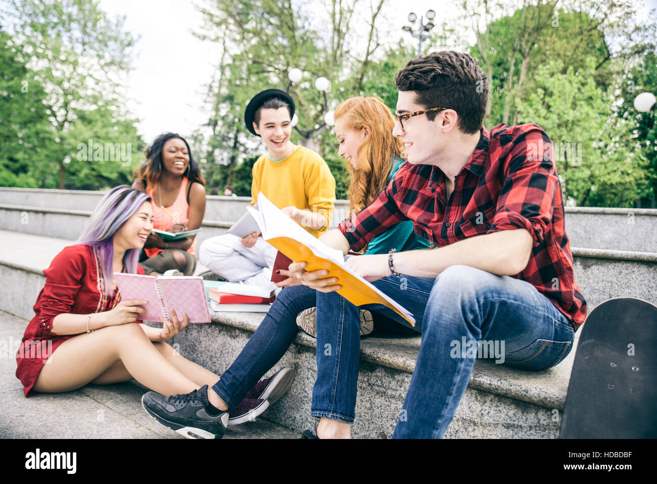 Multi-ethnic group of students stdying together outdoors in a college ...