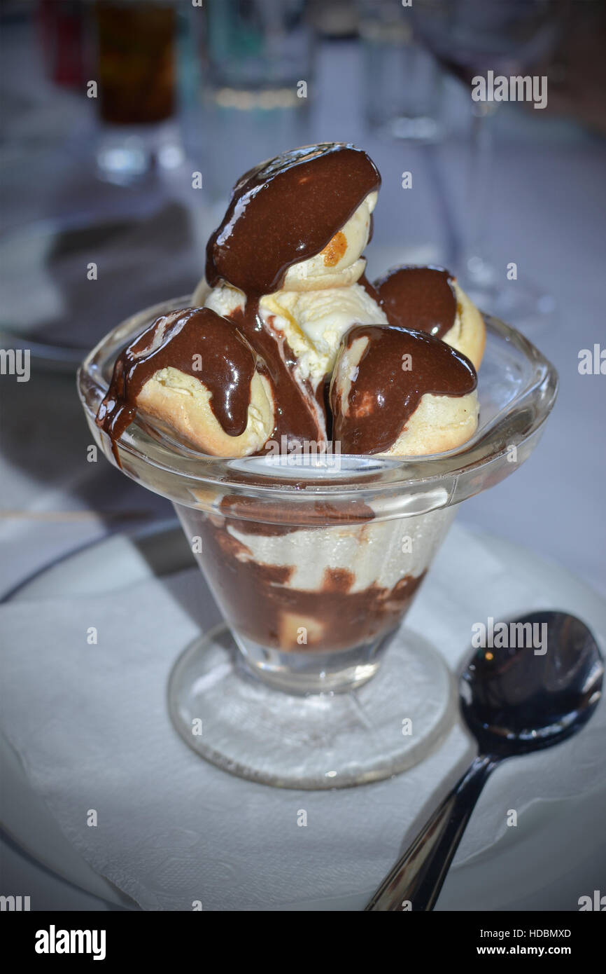 Profiteroles with chocolate sauce and chocolate syrup in a glass bowl ...