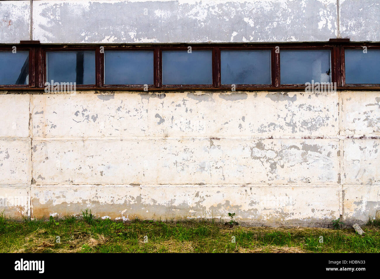 Concrete block wall with a row of windows and ground Stock Photo - Alamy