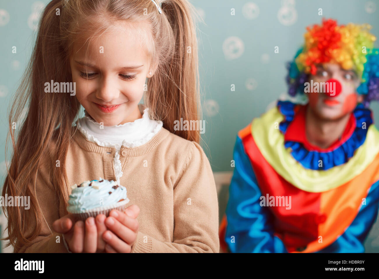 Little girl holds cake in hand and makes a wish Stock Photo - Alamy
