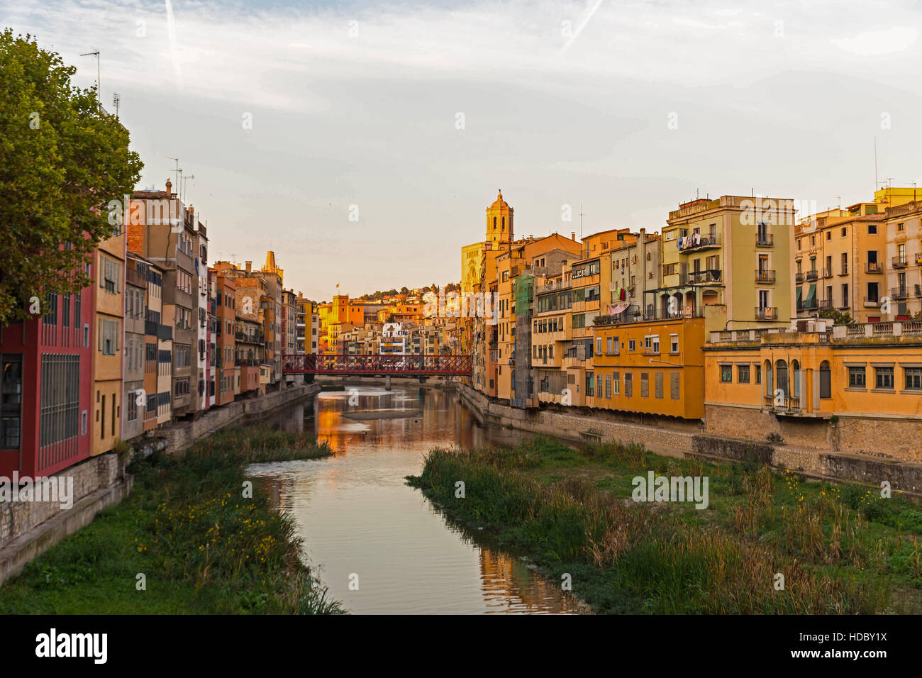 Onyar river crossing the downtown of Girona with bell tower of Basilica ...