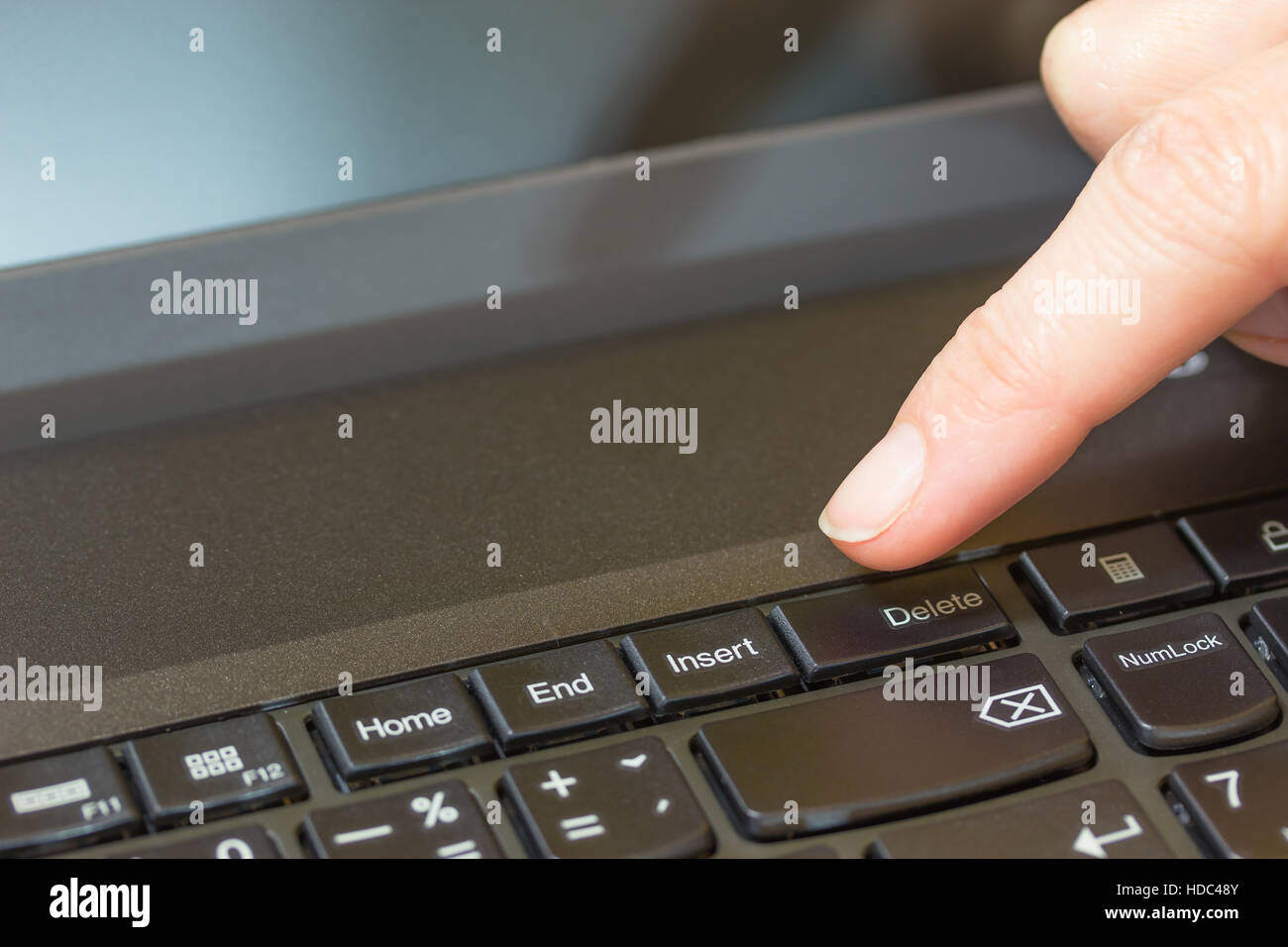 Women finger is ready to press the Delete key on the keyboard of a ...