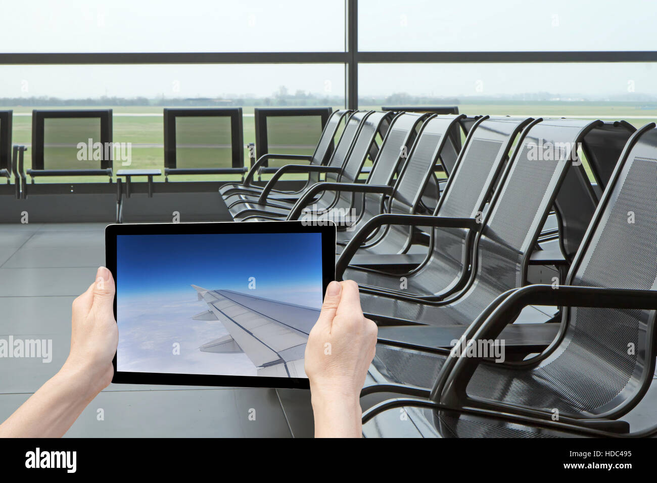 In the bottom left of the photo are hands holding tablet, whose screen ...