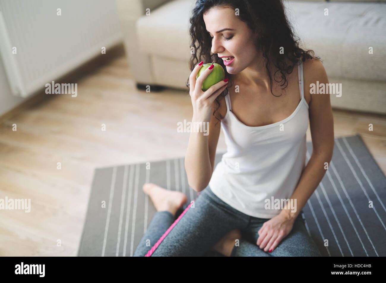 Sporty woman eating healthy apple after exercising Stock Photo - Alamy