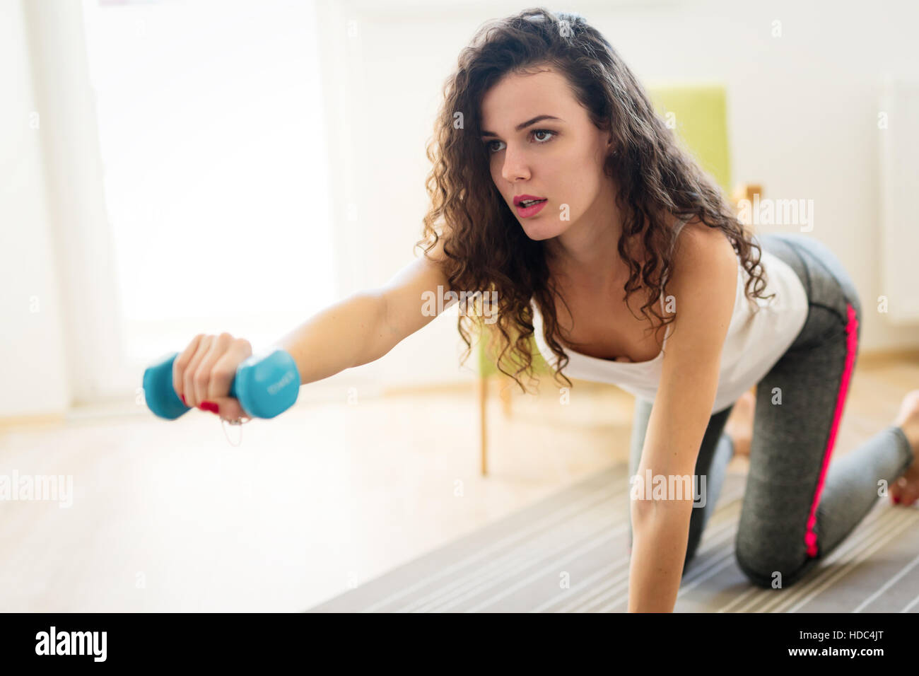 Sporty beautiful woman exercising at home to stay fit Stock Photo - Alamy