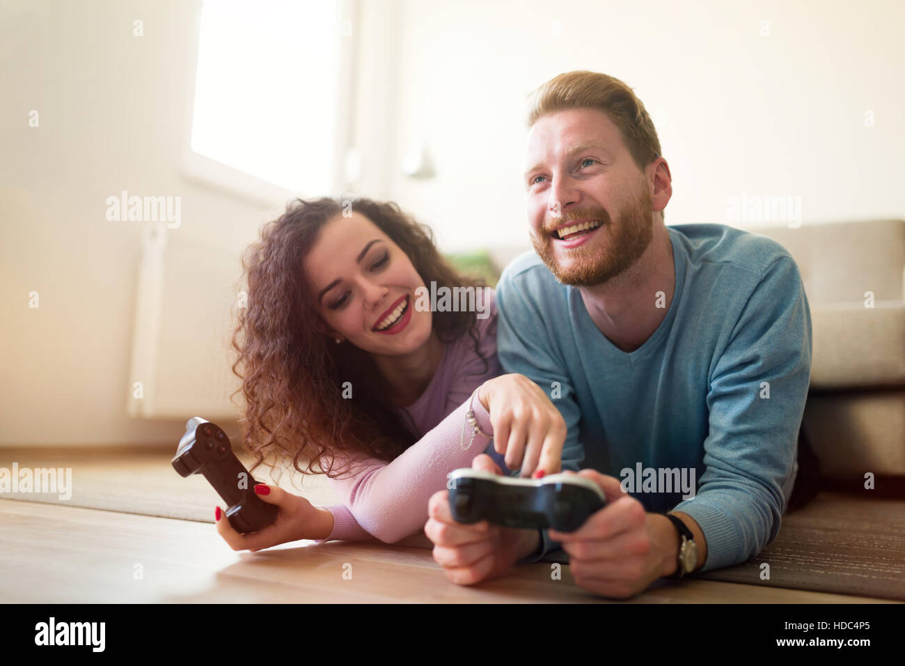 Happy couple playing video games on console and having fun Stock Photo ...