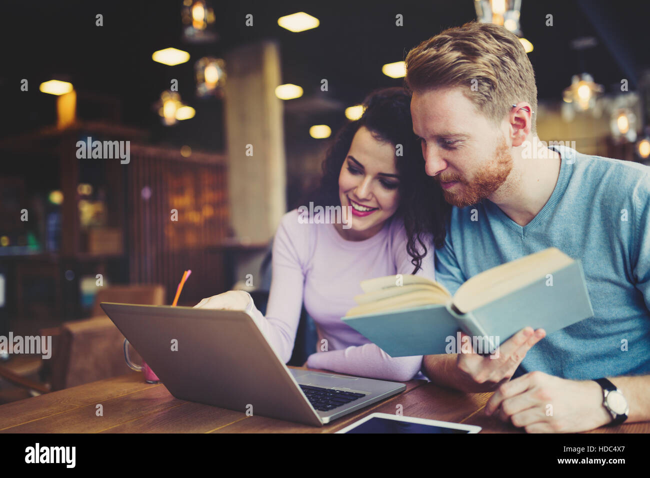 Happy couple studying in library for university exam Stock Photo - Alamy