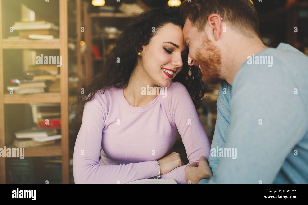 Couple in love flirting in campus library Stock Photo - Alamy
